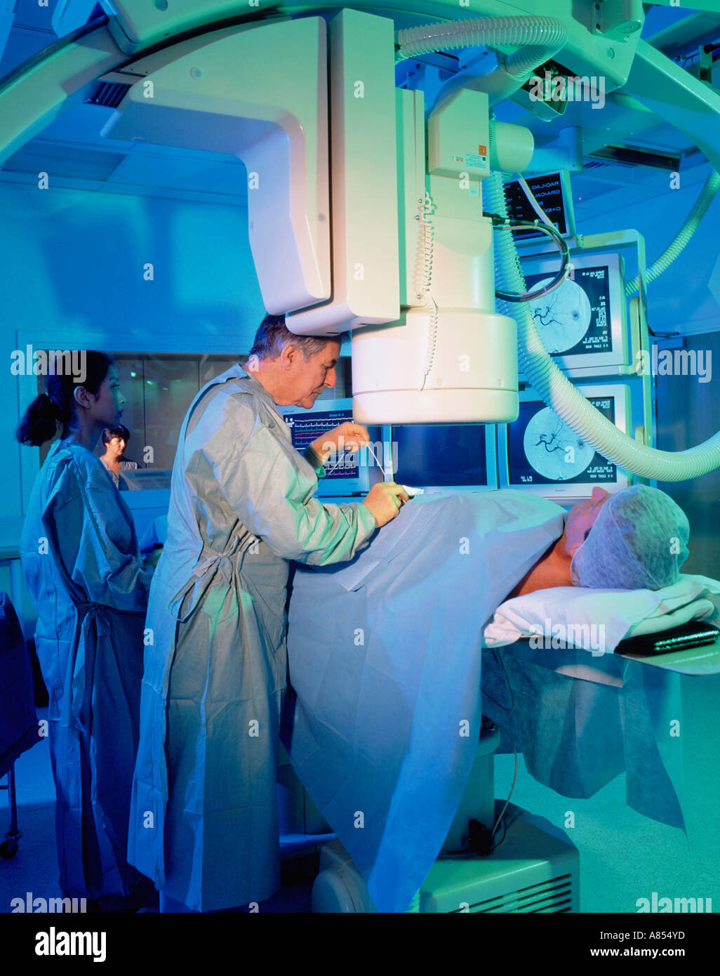 Surgeon and nurse with patient in hospital Angiography scanning room ...