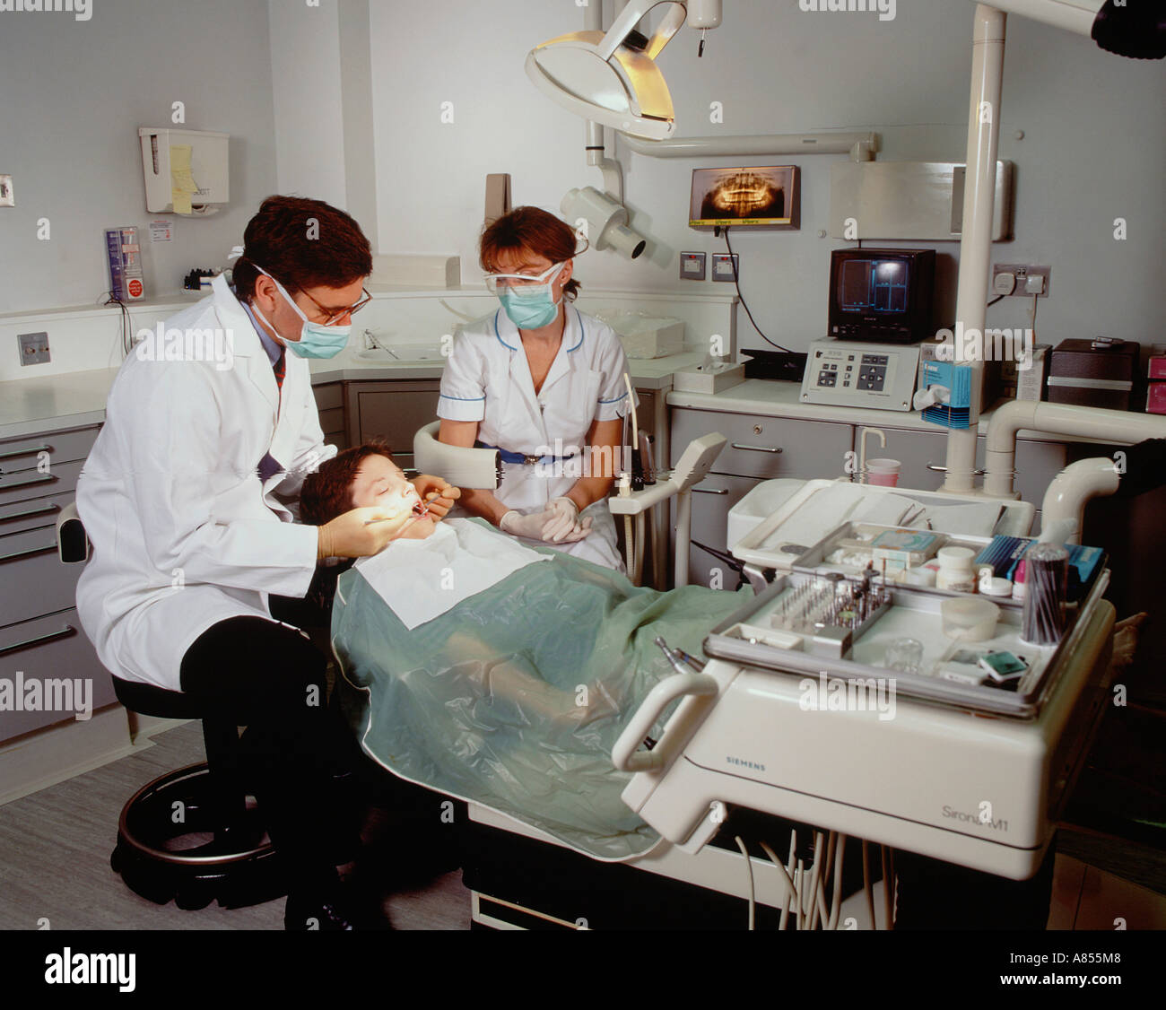 Dentist with nurse and child boy patient Stock Photo - Alamy