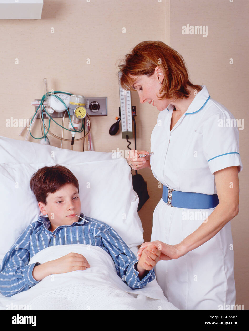 Nurse tending to young boy patient in hospital bedroom Stock Photo - Alamy