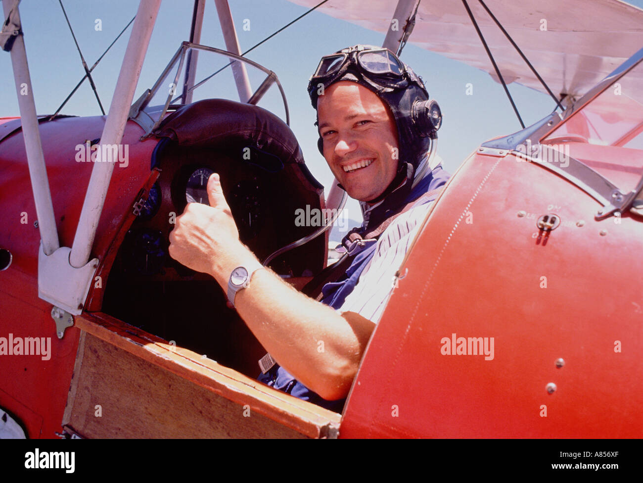 Young man aviator pilot giving thumbs up sign from cockpit of old ...
