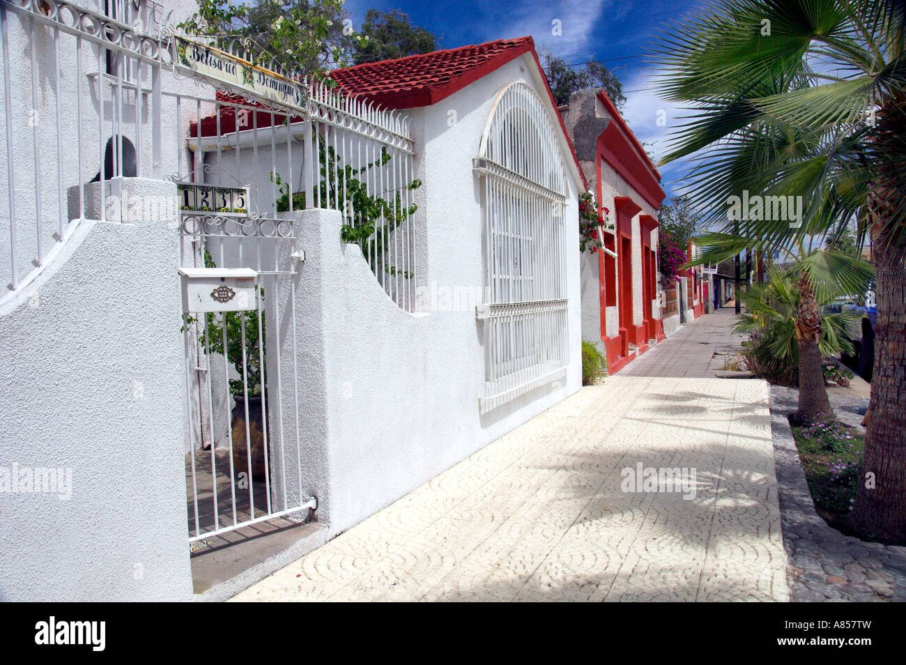 A well maintained Mexican residential street with whitewashed buildings ...