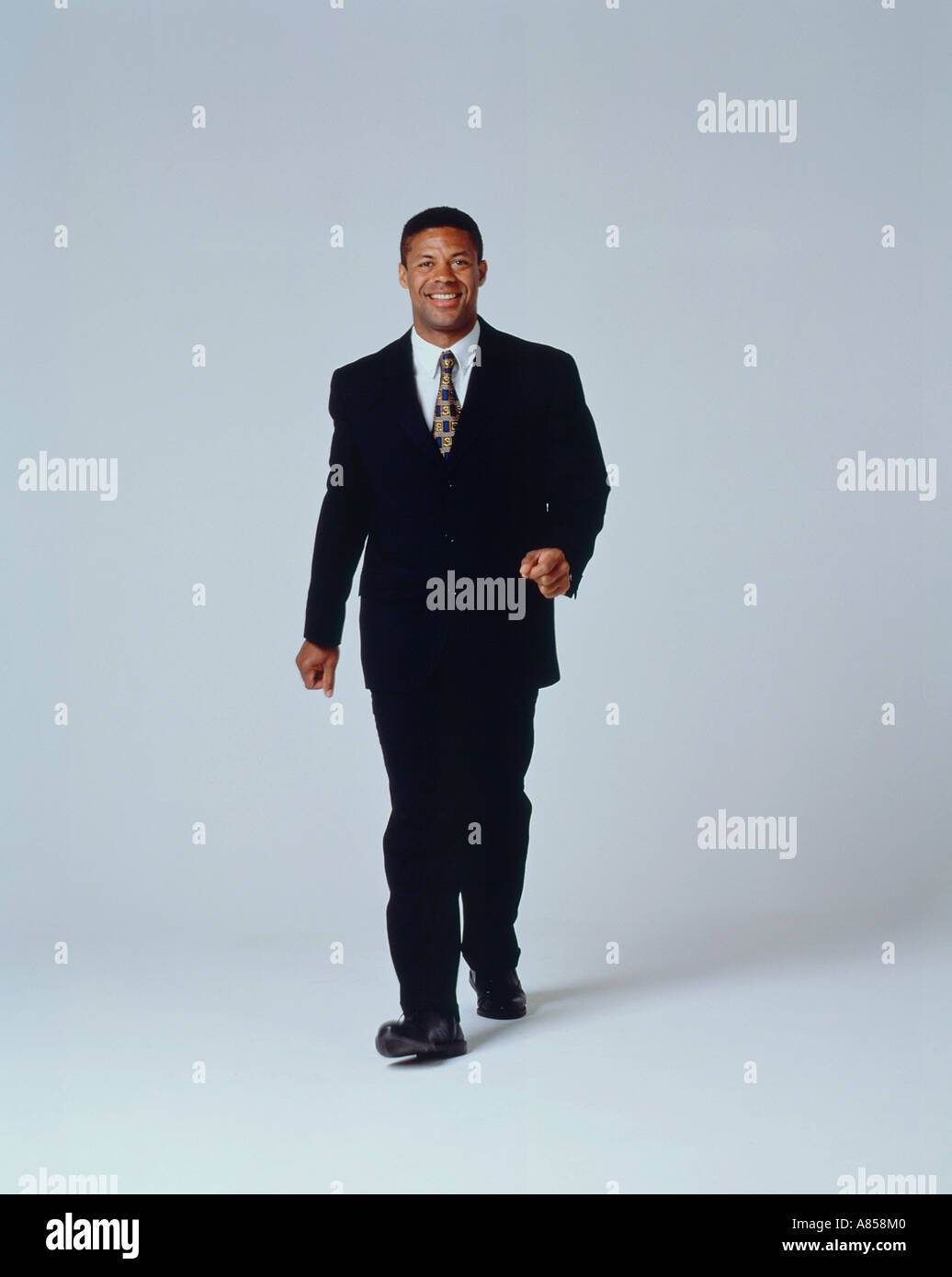 Studio image of young, happy black man walking towards camera Stock ...