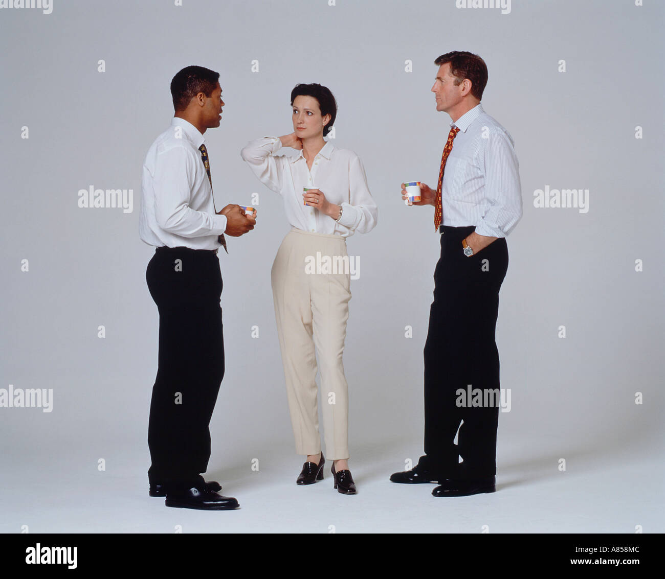 Indoor studio full length image of three people talking to each other ...