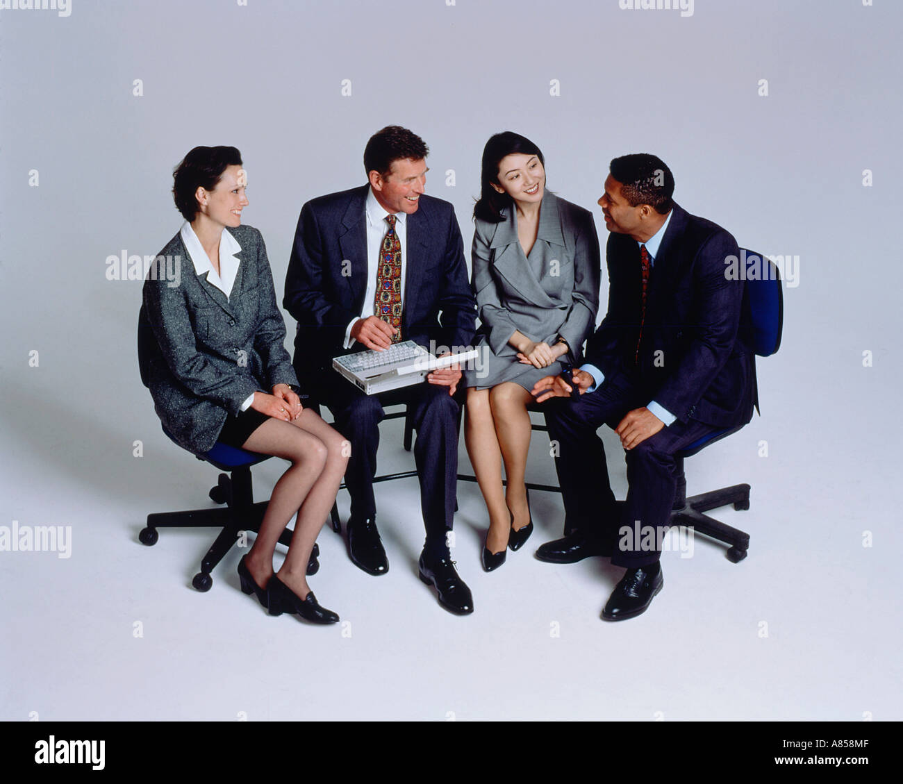 Indoor studio full length image of four seated people talking to each ...