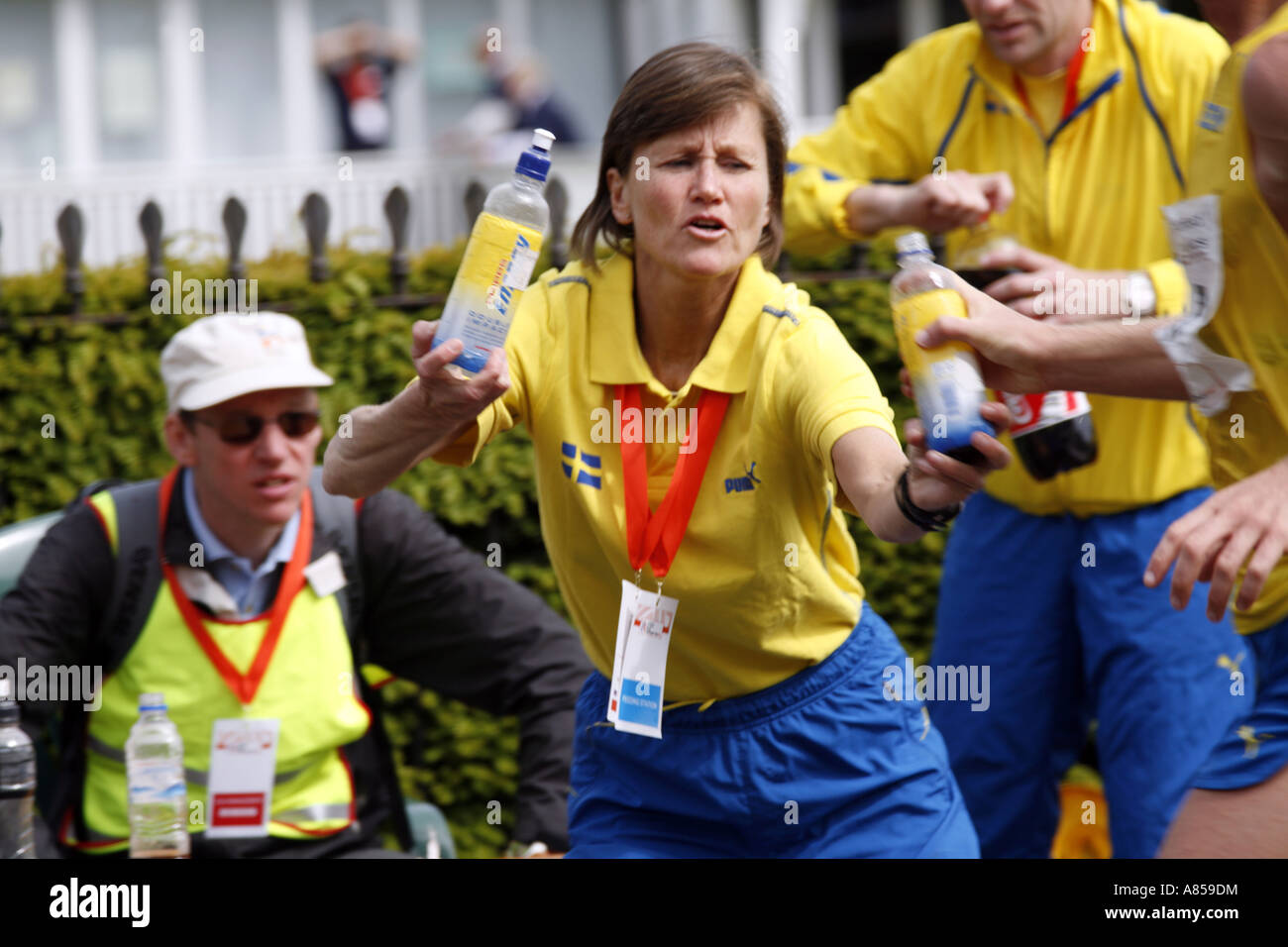 Coach handing water to athletes Stock Photo - Alamy