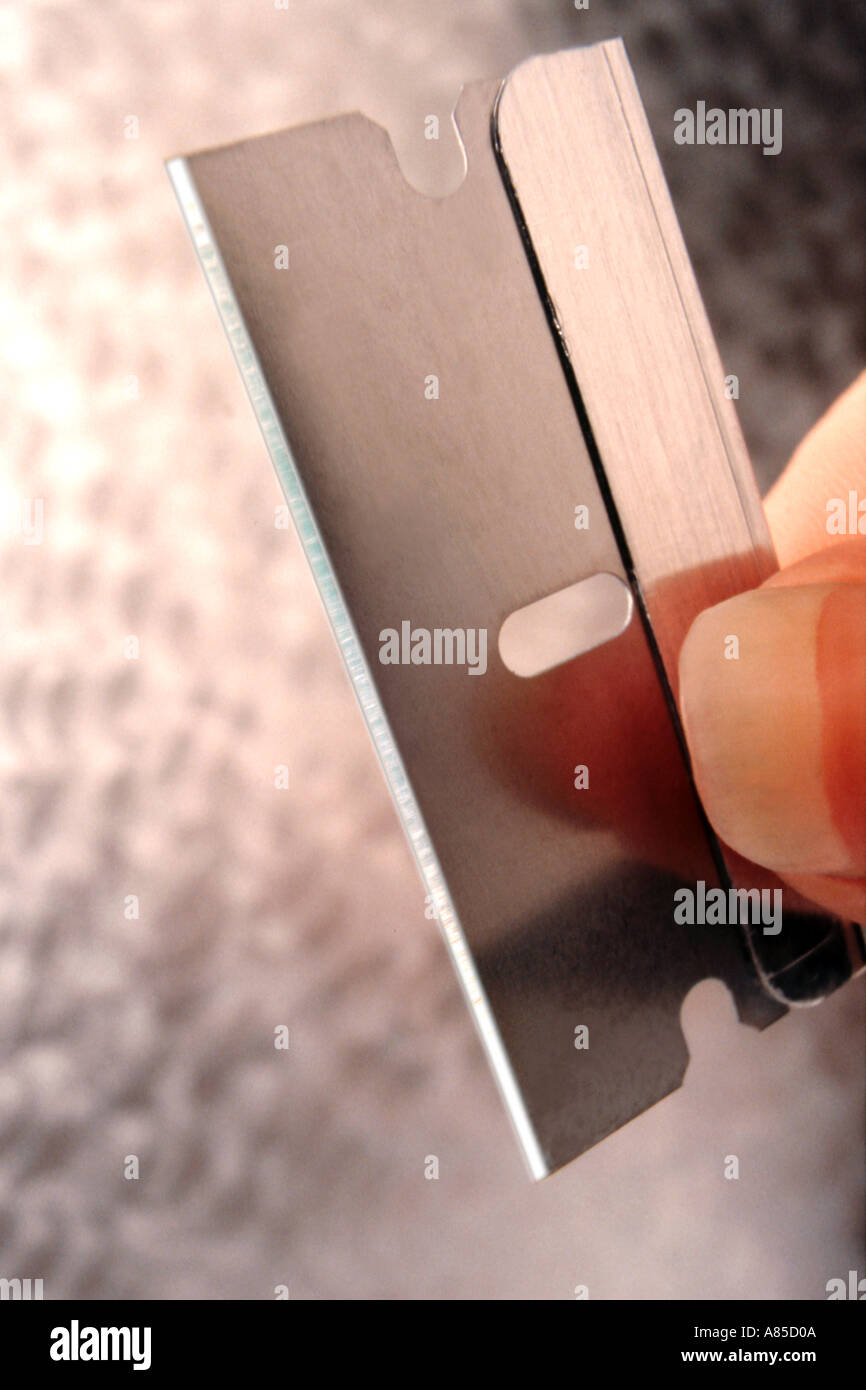 Sharp razor blade being held in fingers Stock Photo - Alamy