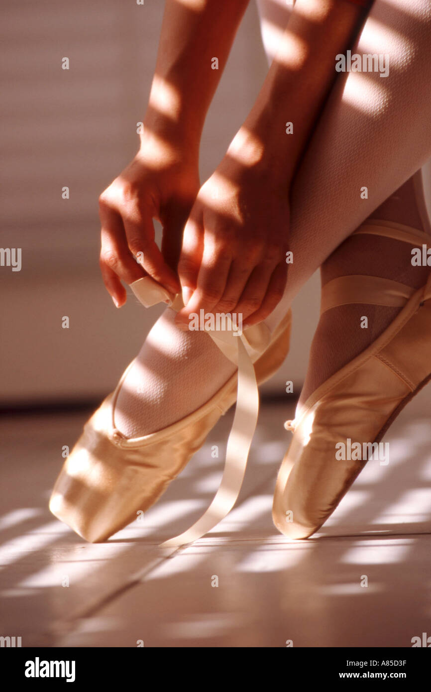 Ballet dancer tying ballerina shoes Stock Photo - Alamy