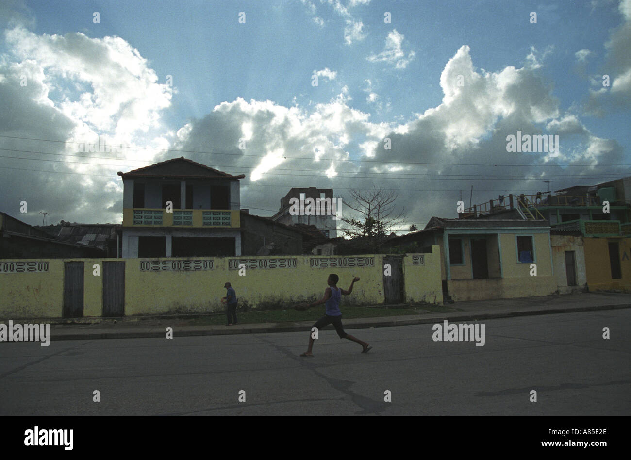 Cuban boy plays baseball in street on the malecon of Barracoa Cuba as ...