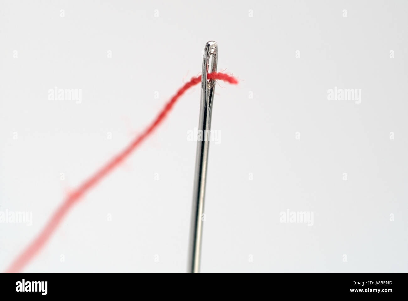 Needle threaded with red thread hi-res stock photography and images - Alamy
