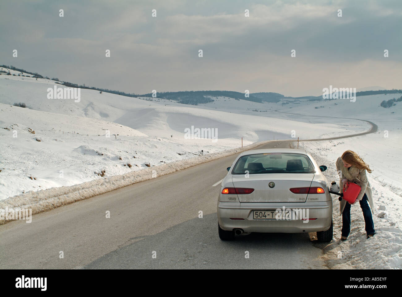 Woman Refilling Her Car with Petrol After Breaking Down on an Isolated ...