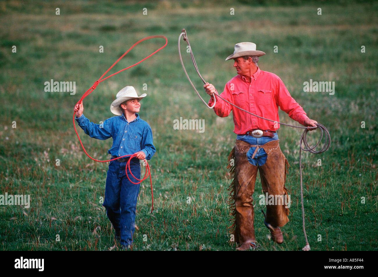 Cowboy teaching a young boy to rope Stock Photo - Alamy