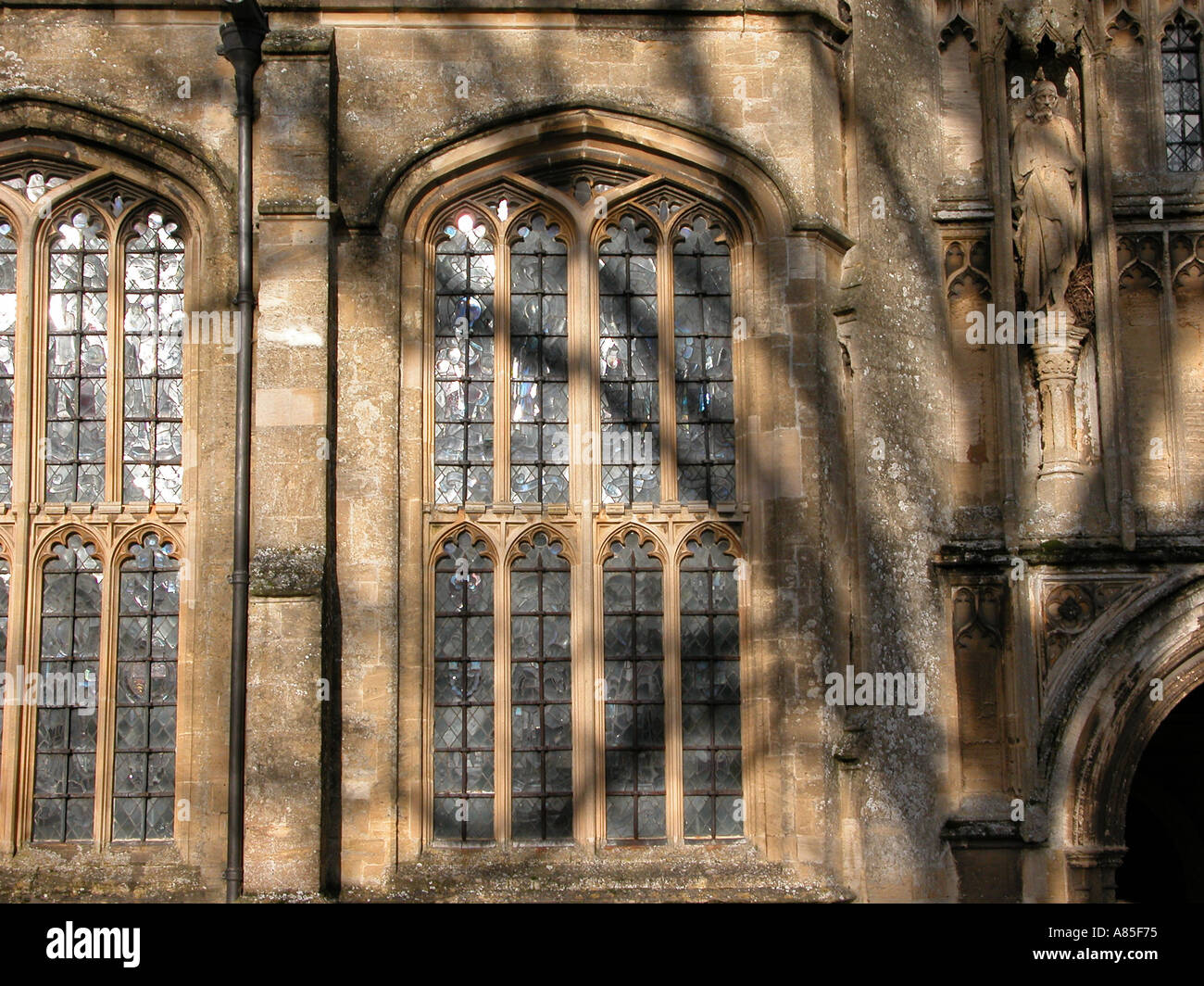 Burford church window with leafless tree shadow UK Stock Photo - Alamy