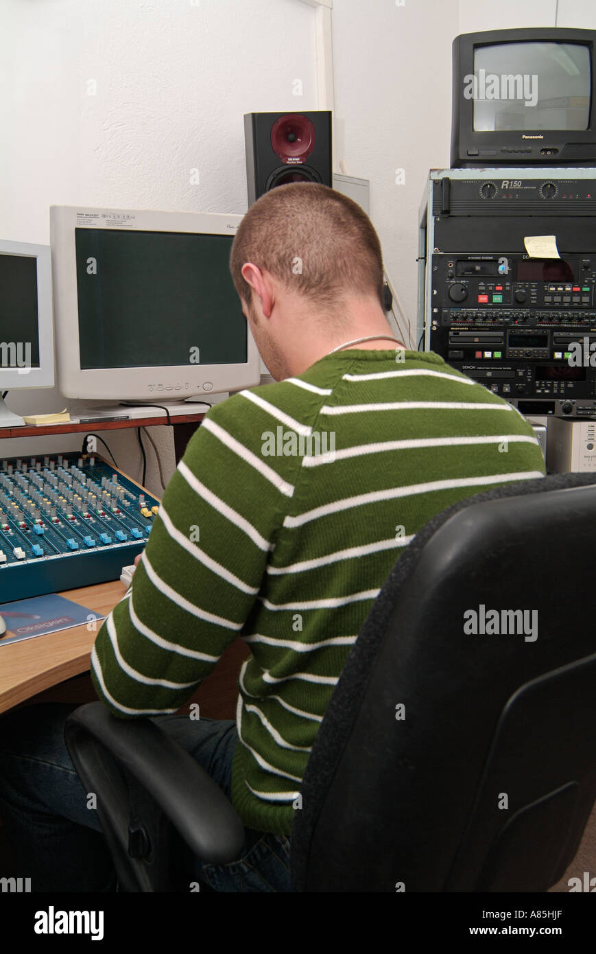 Young Caucasian Male Sat At A Computer Workstation In The Production ...
