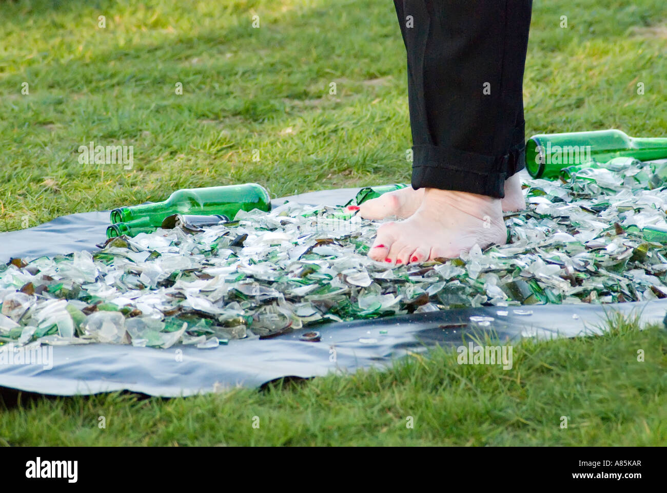 Walking with bare feet on broken glass at charity fund raising event ...