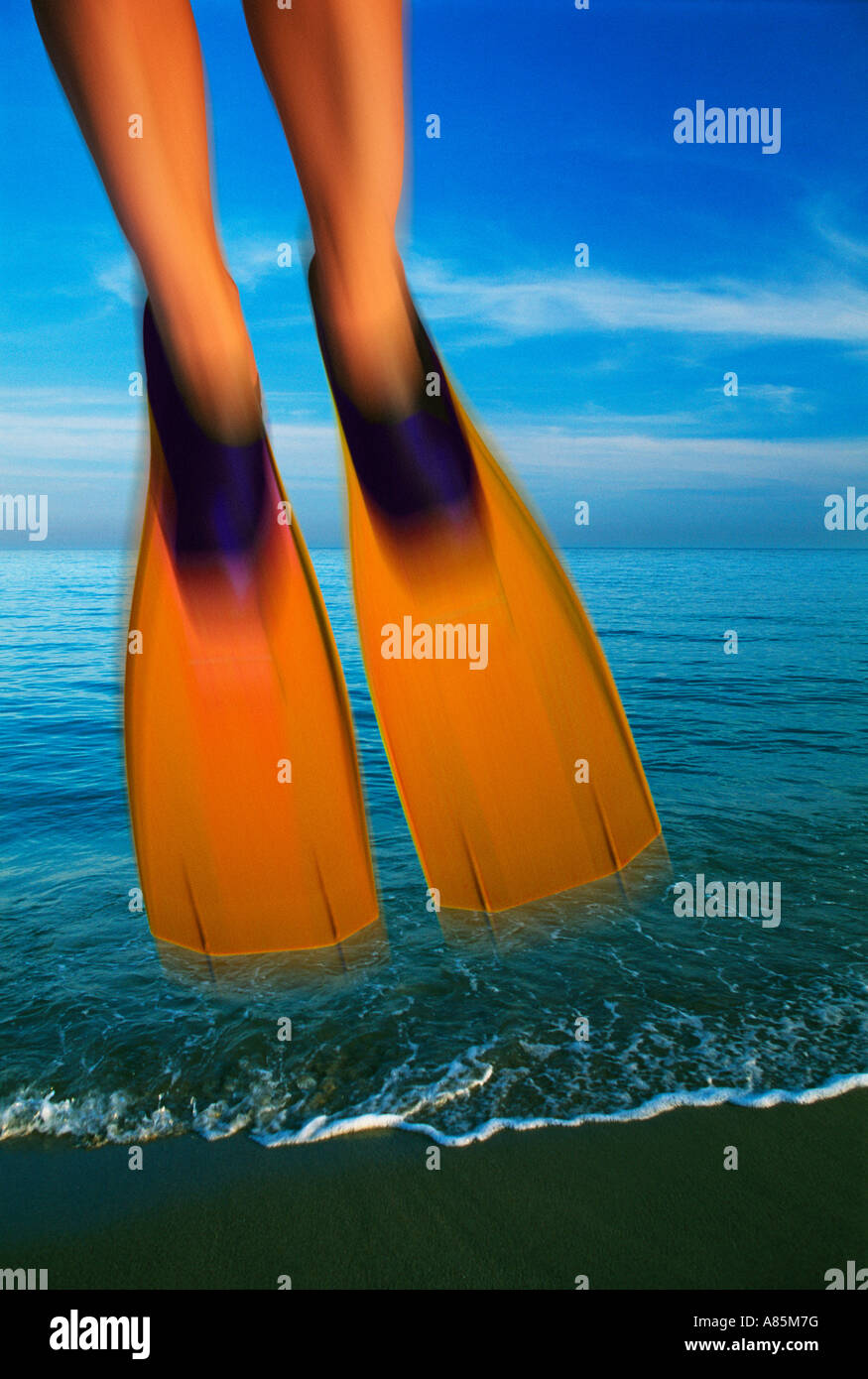 WOMAN JUMPING UP WITH DIVING FLIPPERS ON THE BEACH Stock Photo - Alamy