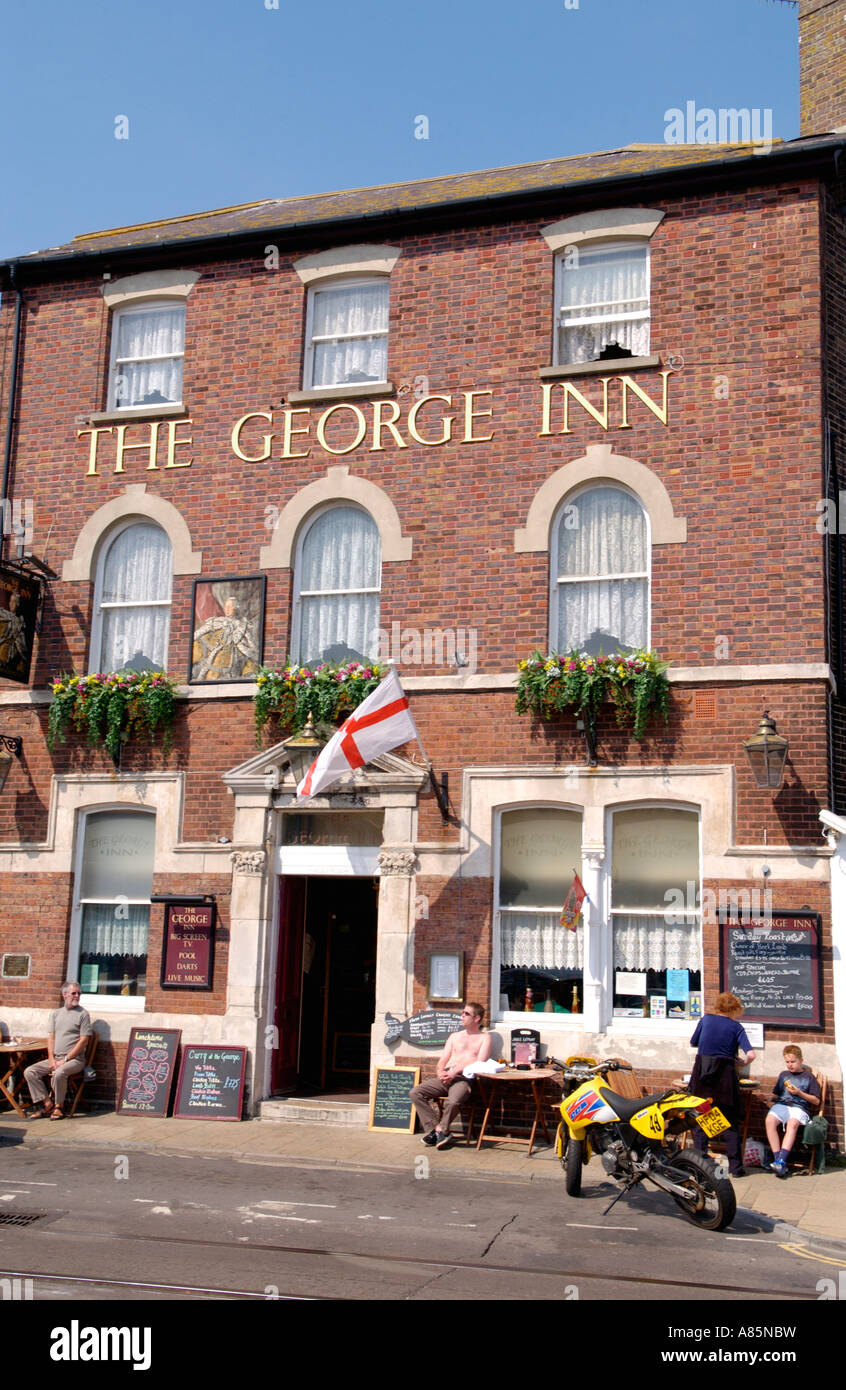 People drinking in sunshine outside THE GEORGE INN public house on the ...