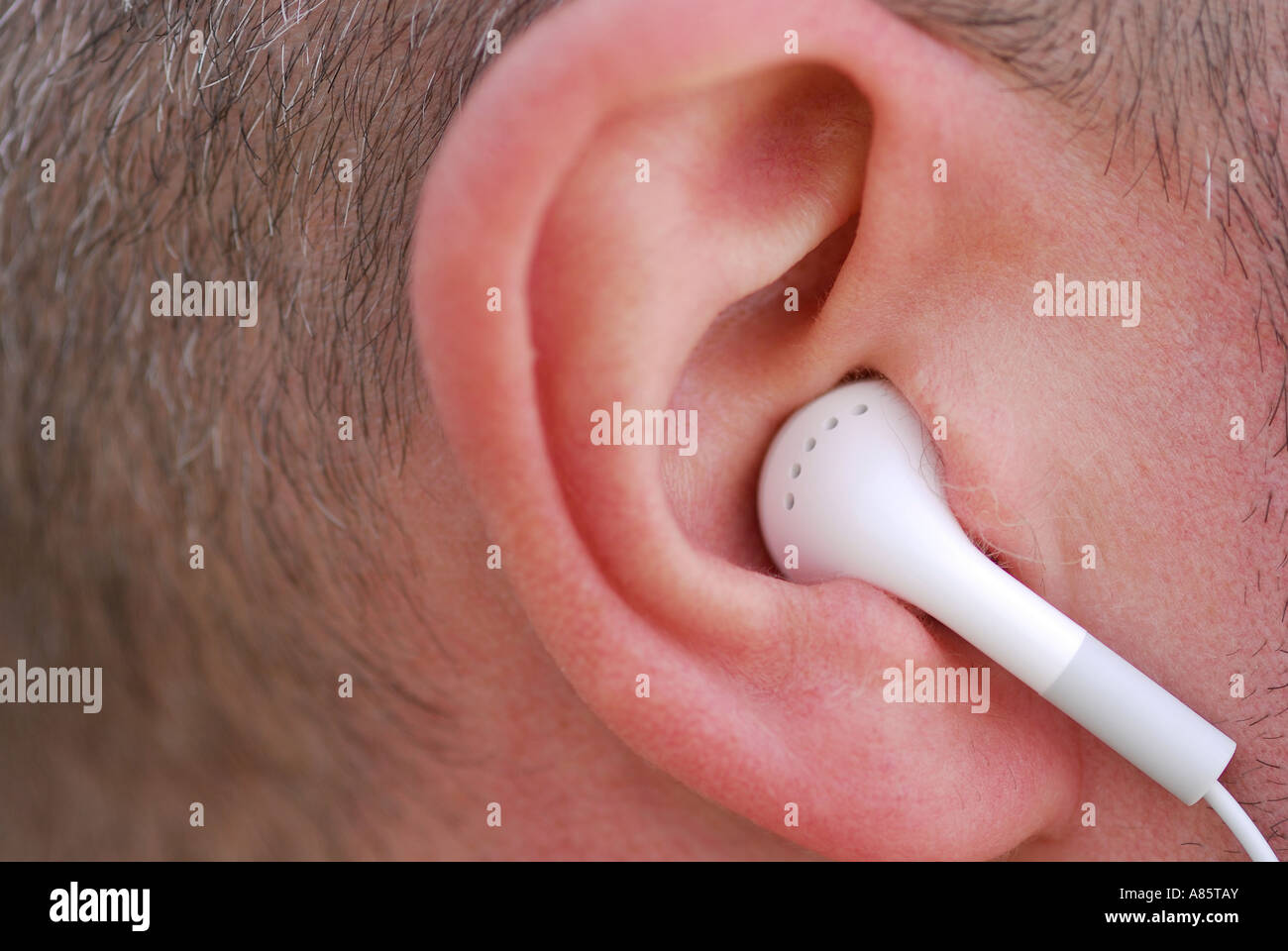 ipod mp3 player earpiece in male ear Stock Photo - Alamy