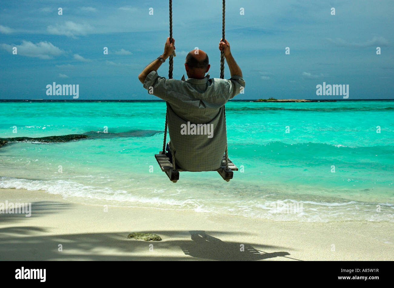 A tourist swings on a beach swing in the Maldives Stock Photo - Alamy