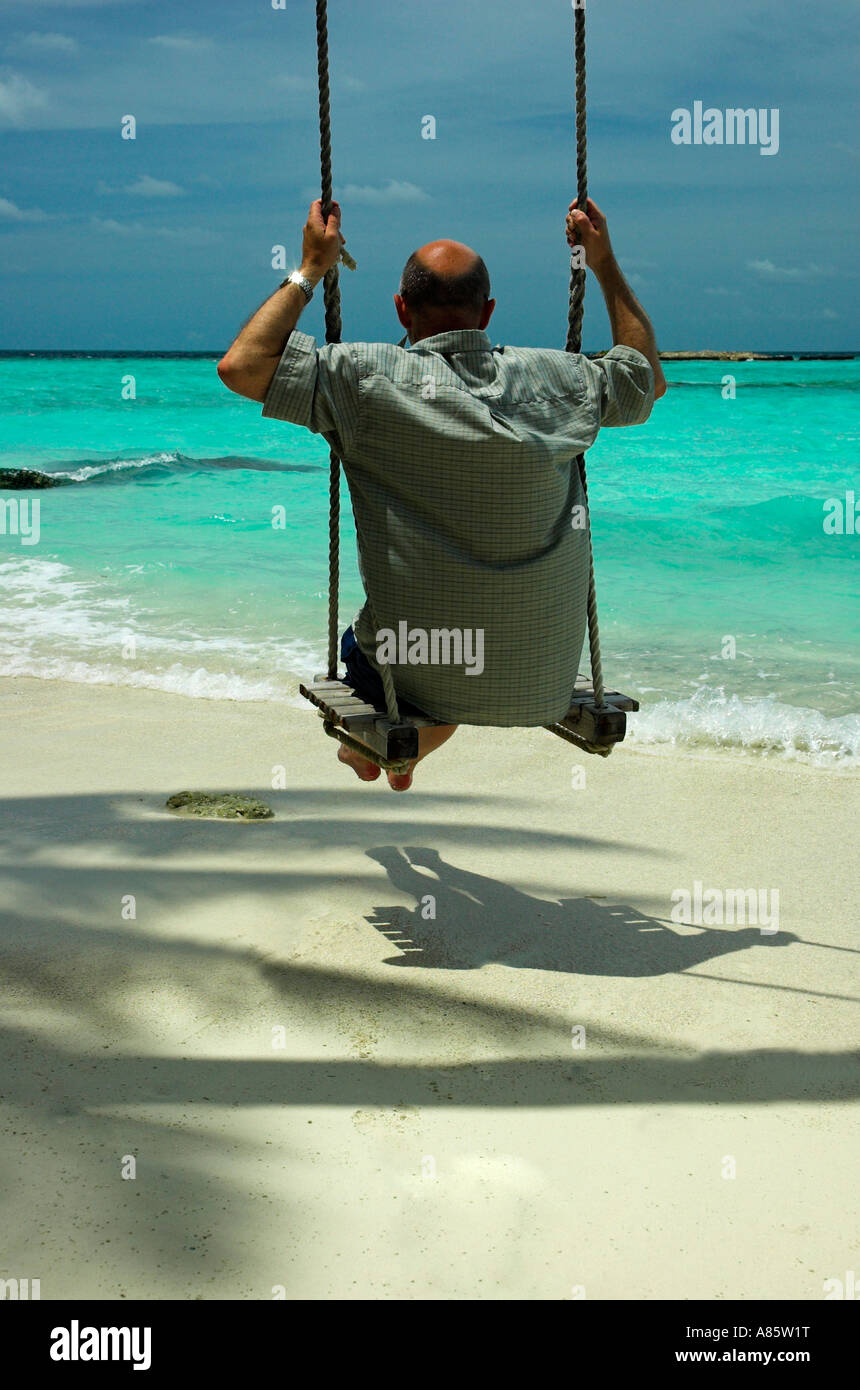 A tourist swings on a beach swing in the Maldives Stock Photo - Alamy