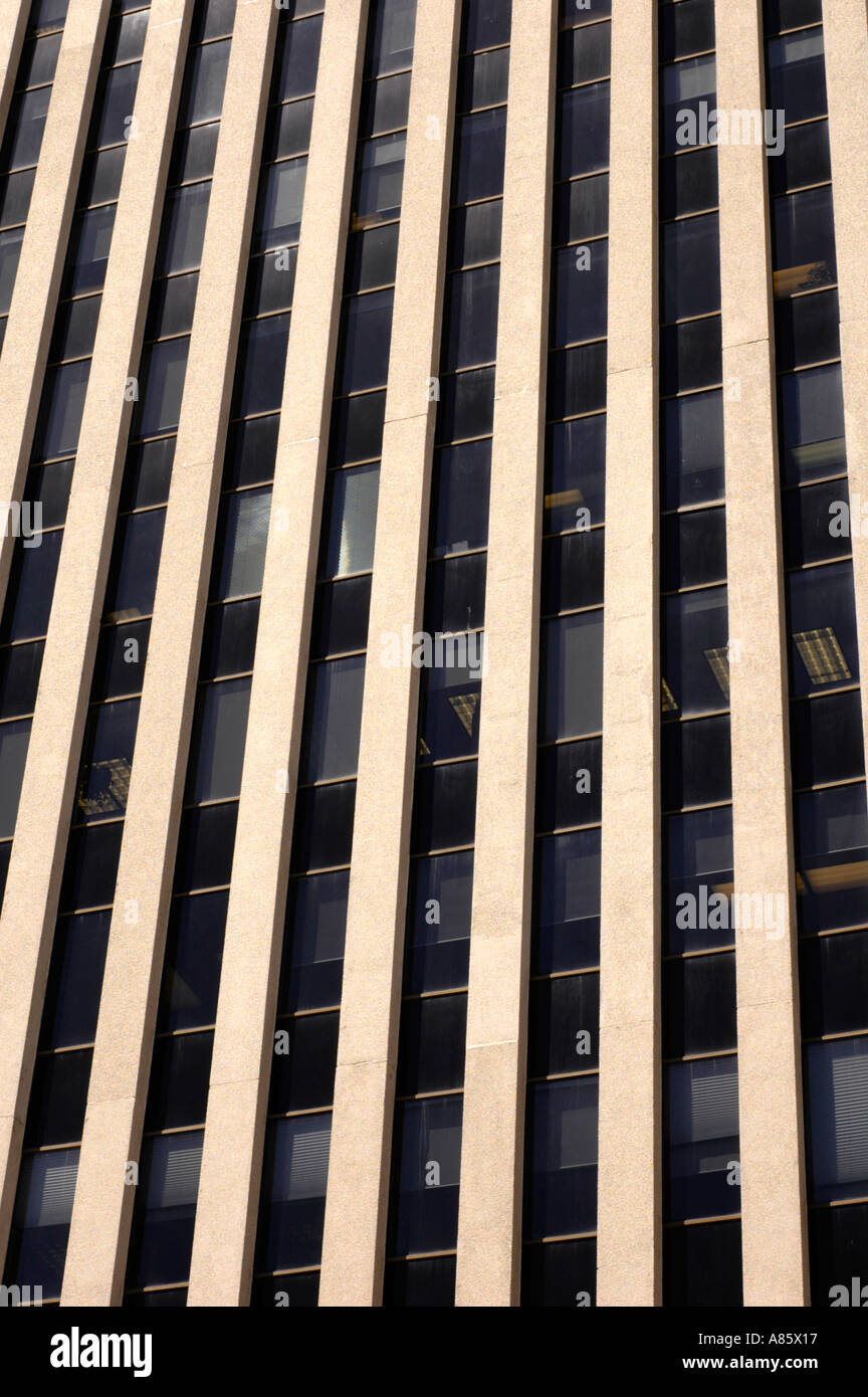 Modern skyscraper like building with tall white columns and black glass ...