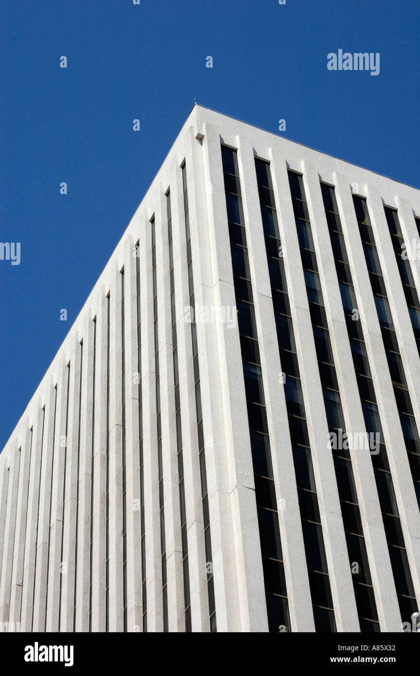 Modern skyscraper like building with tall white columns and black glass ...