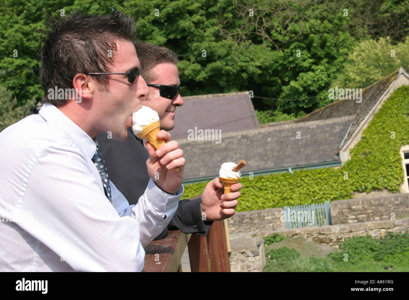 Two men eating ice creams on a hot day in Bibury Gloucestershire Stock ...