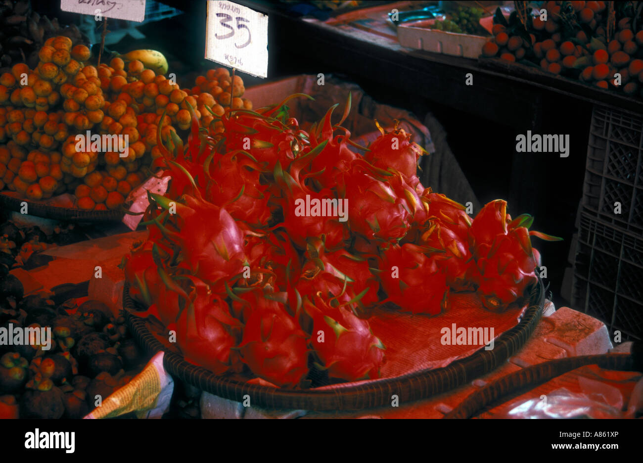 Dragon fruit on display with lychees behind on market stall in Wichian ...