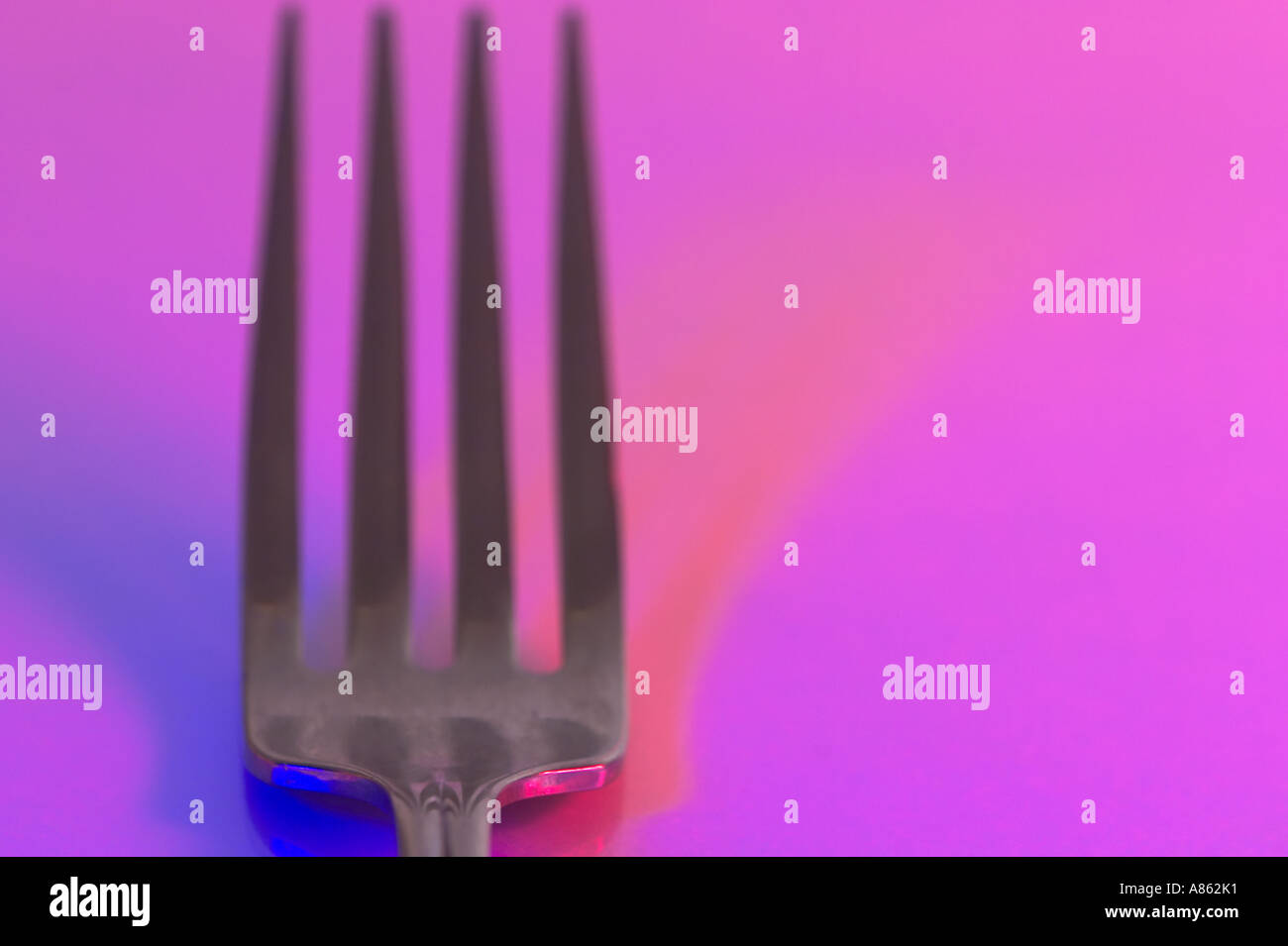 A fork and its reflection with red, blue and violet light Stock Photo ...