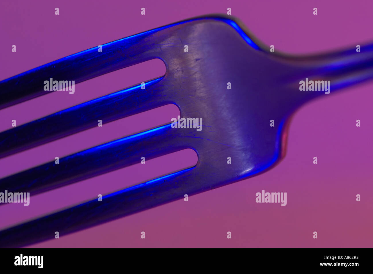 A fork and its reflection with red, blue and violet light Stock Photo ...