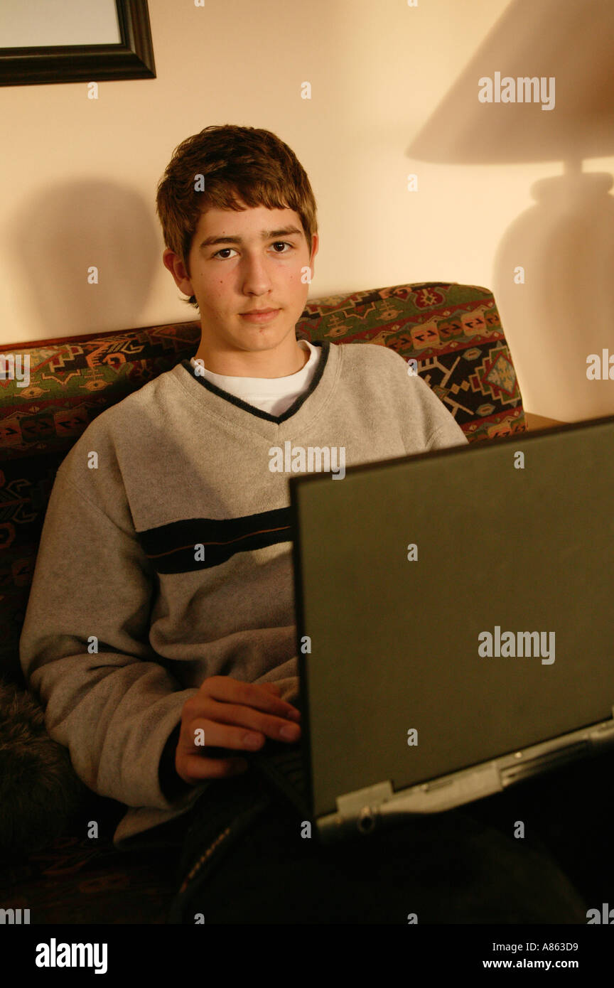 Boy using laptop computer inside Stock Photo - Alamy