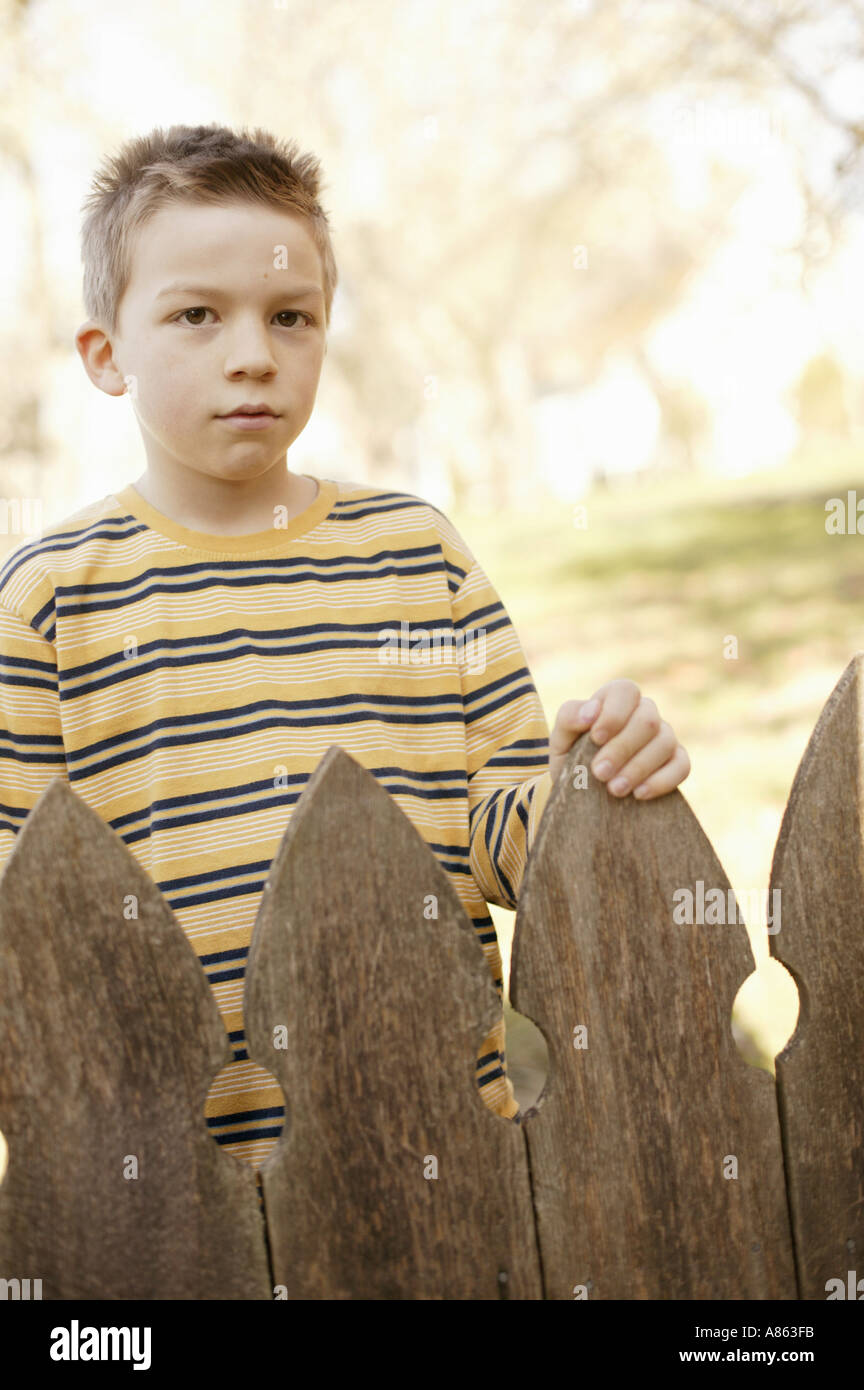 Boy looking over fence Stock Photo - Alamy