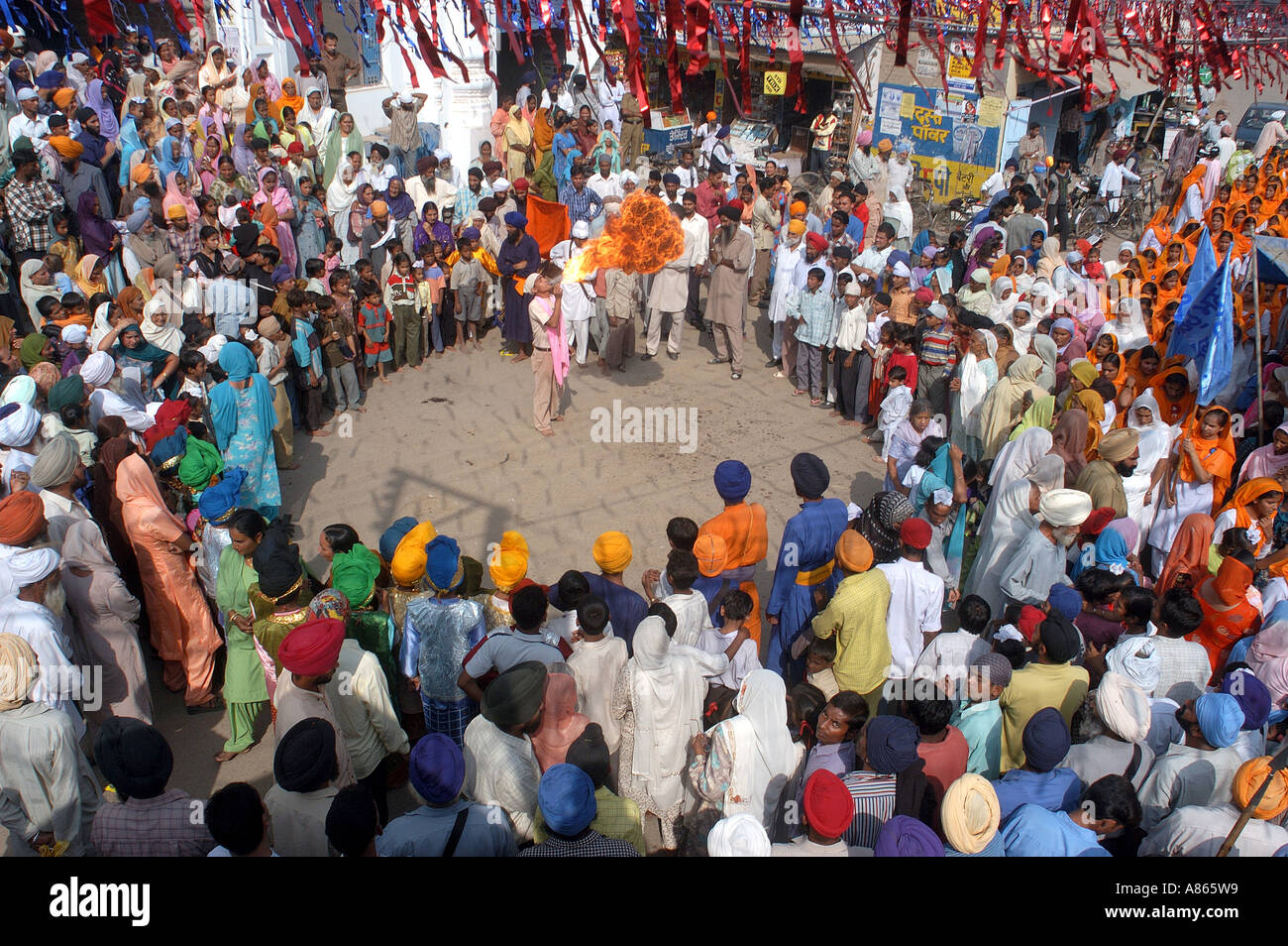 crowd of people in a circle around man blowing fire from his mouth ...