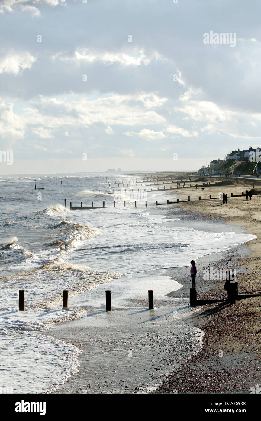 Spring beach landscape with small family playing on the edge of the sea ...