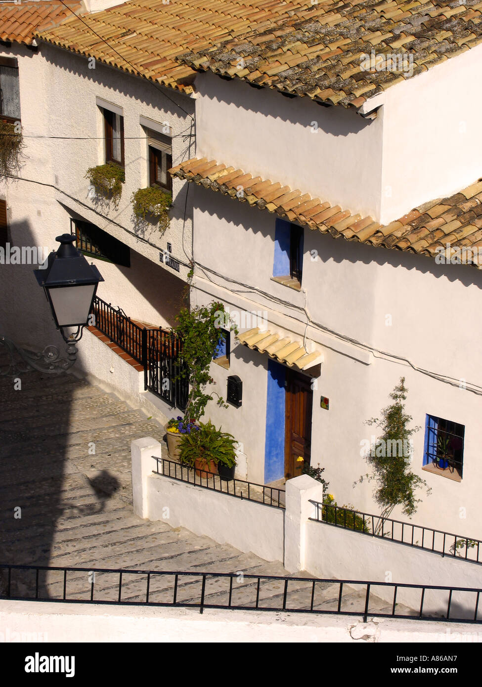 Street with steps in a spanish village with typical white houses Stock ...