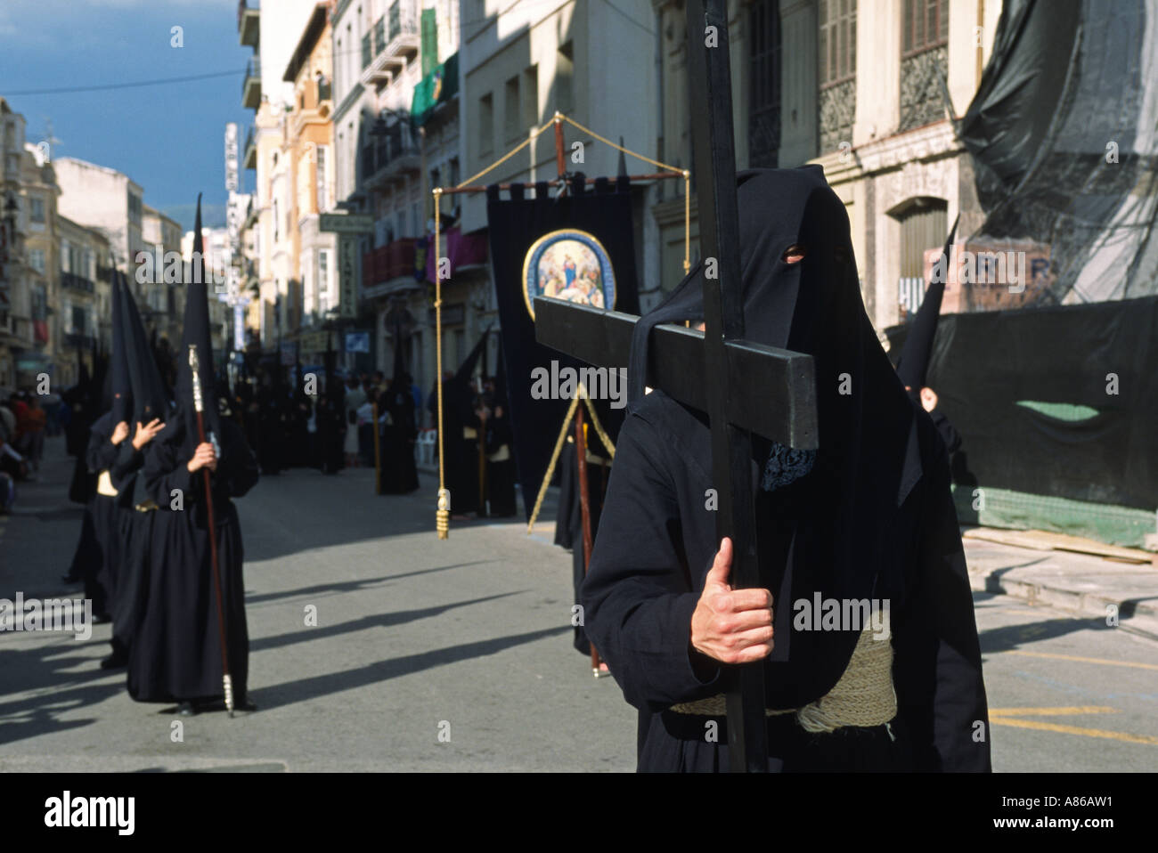 Easter procession in Spain man in black with the holy cross at his ...
