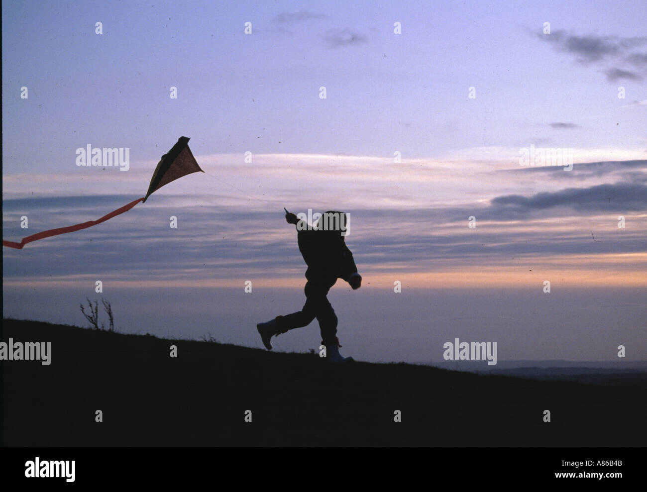 Child running with kite Stock Photo - Alamy