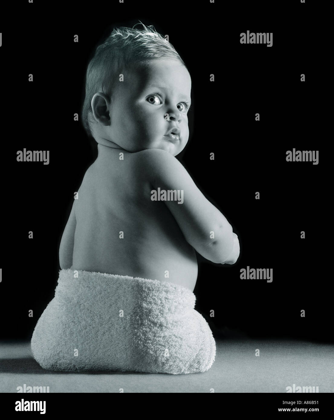 Baby in nappy looking over it's shoulder Stock Photo - Alamy