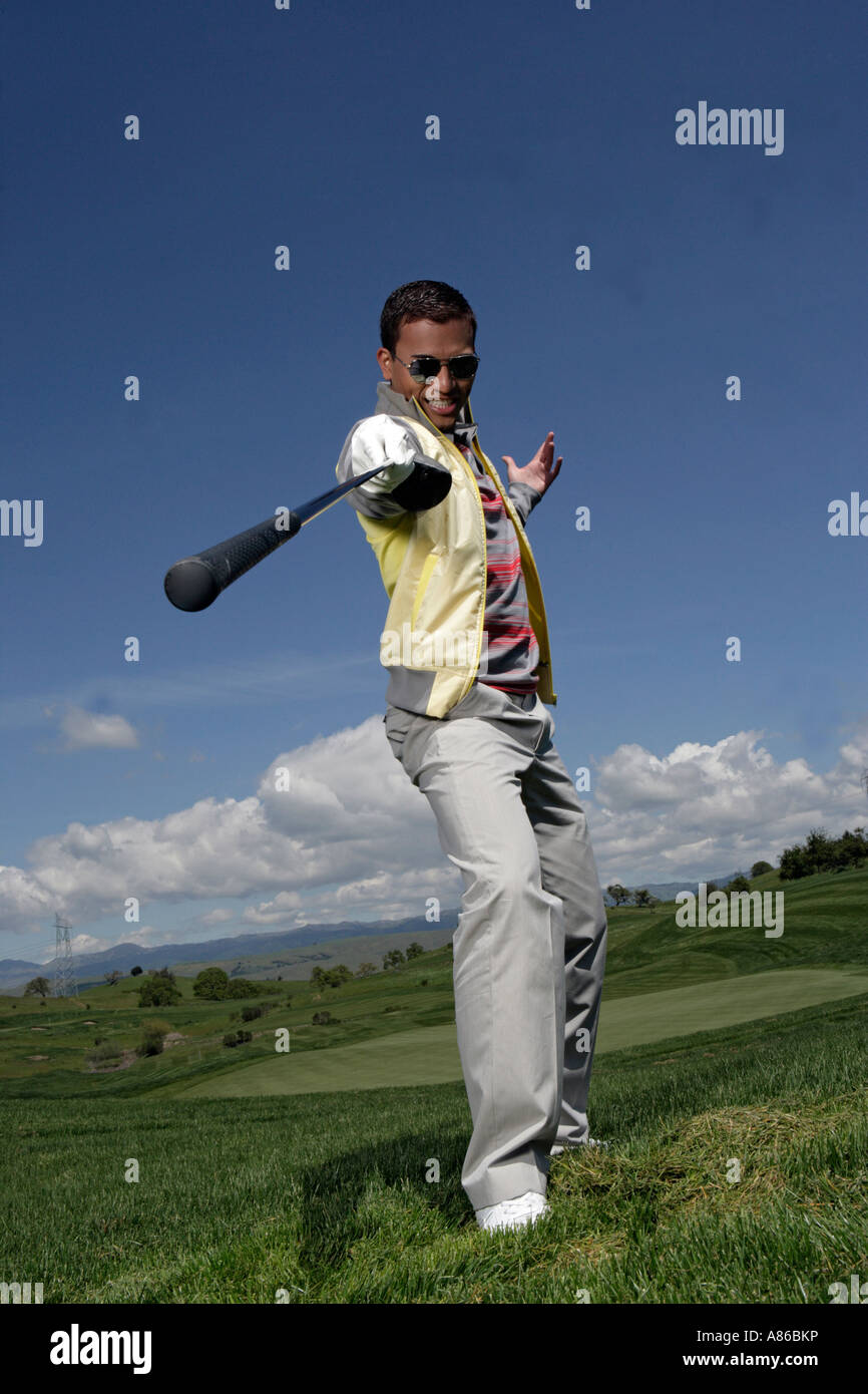 Portrait of a young man posing with a golf club Stock Photo - Alamy