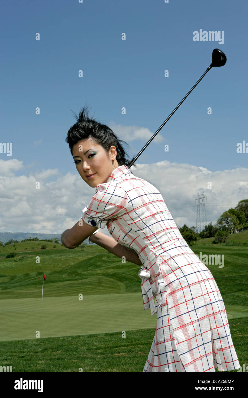 Portrait of a young woman posing with a golf club Stock Photo - Alamy