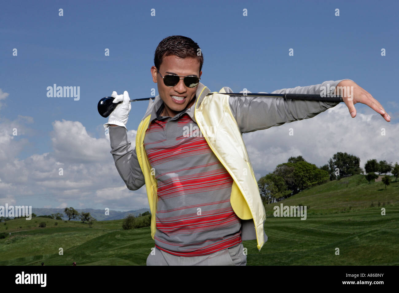 Man wearing shades posing with a golf club over his shoulders Stock ...
