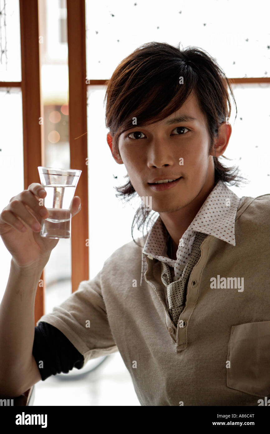 Young Asian man holding glass Stock Photo - Alamy