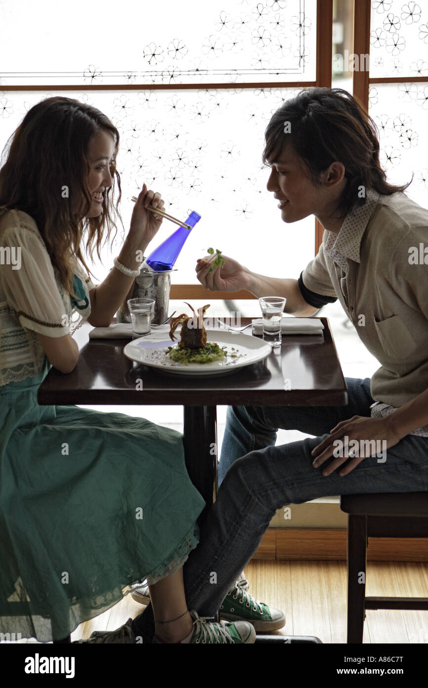 Young couple sitting in restaurant, side view Stock Photo - Alamy