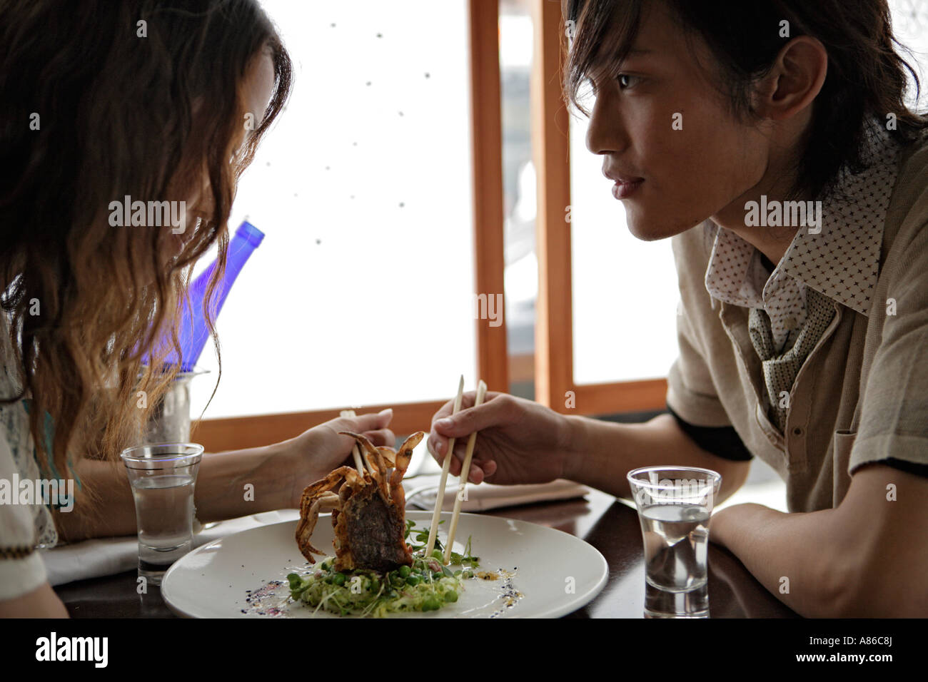 Young couple eating, side view Stock Photo - Alamy