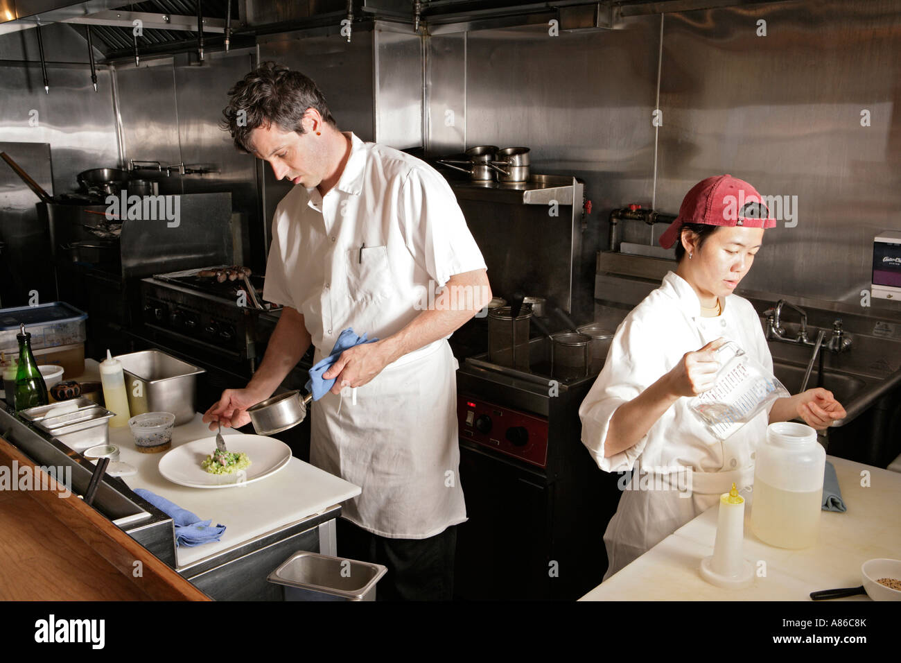 Two people preparing food, side view Stock Photo - Alamy