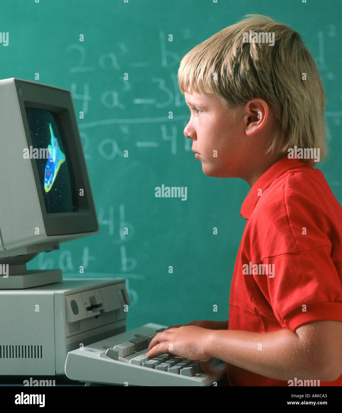 young boy working on computer in school classroom Stock Photo - Alamy