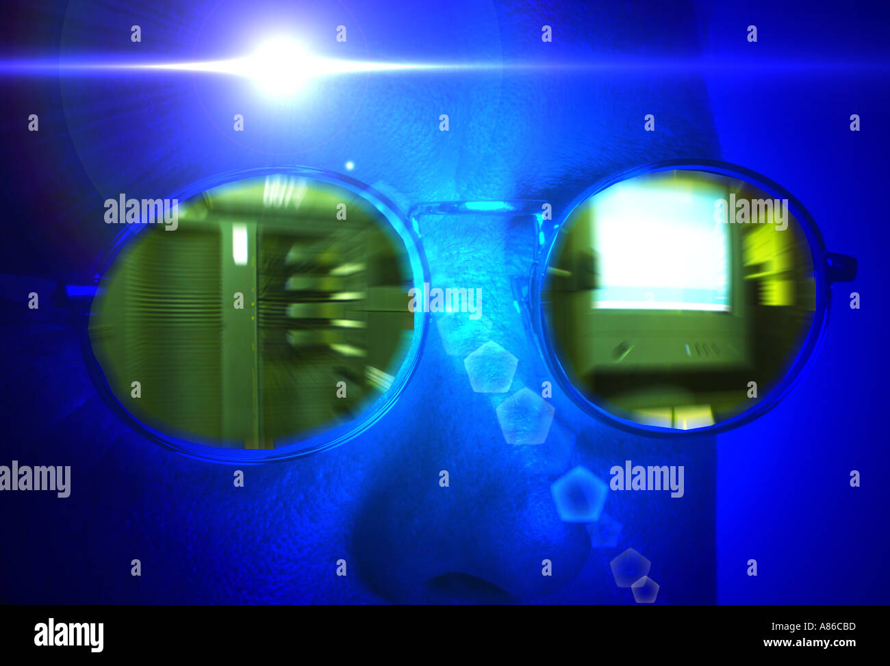 worker in darkened computer lab with reflections of lab in glasses ...