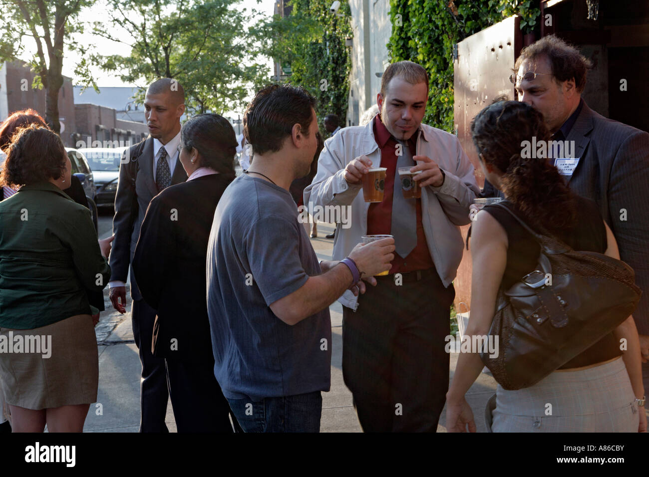 Group of people standing on the street drinking Stock Photo - Alamy