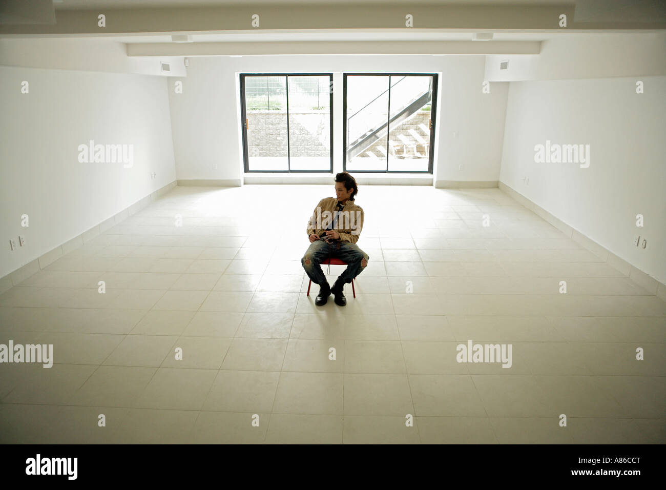 One young man sitting inside room, high angle view Stock Photo - Alamy