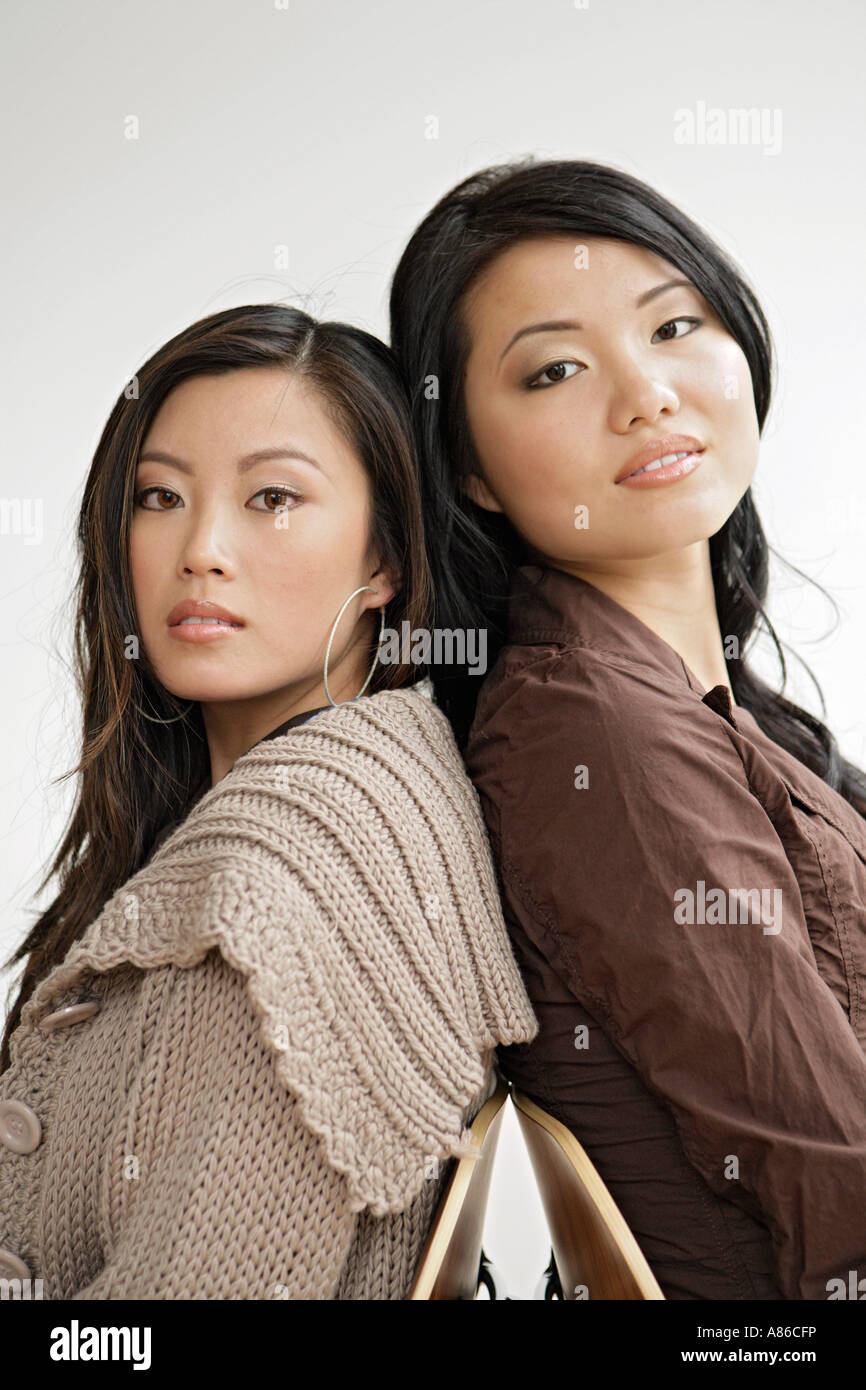 Two young women back to back, portrait Stock Photo - Alamy