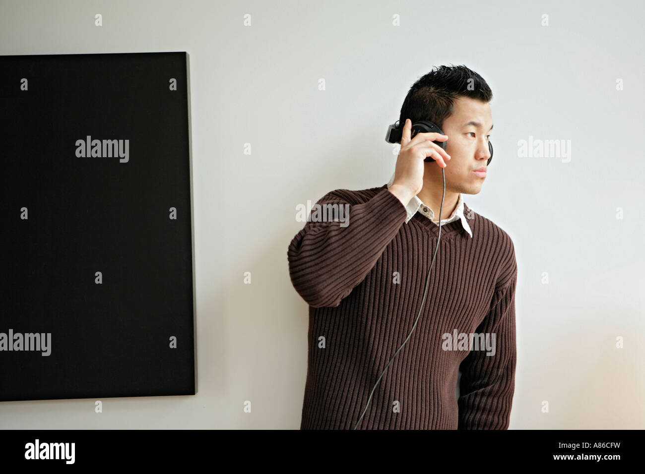 Young man hearing music, front view Stock Photo - Alamy